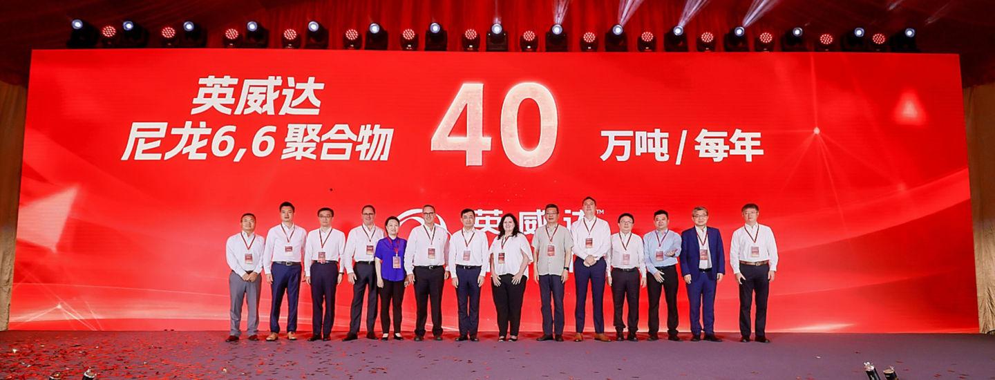 INVISTA team standing behind INVISTA logo